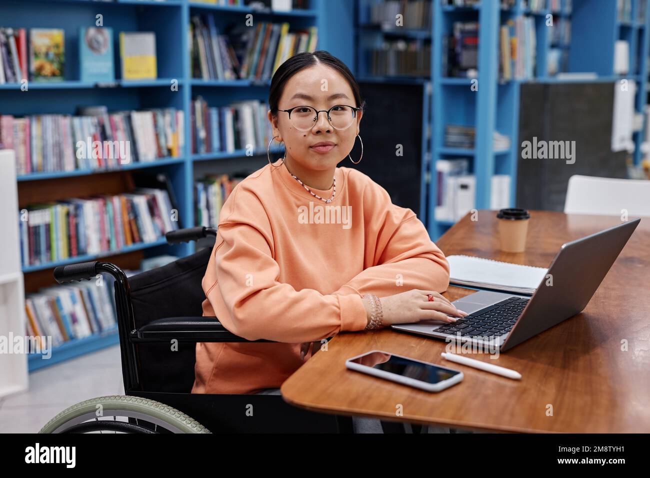 Portrait of Asian young woman with disability as college student ...