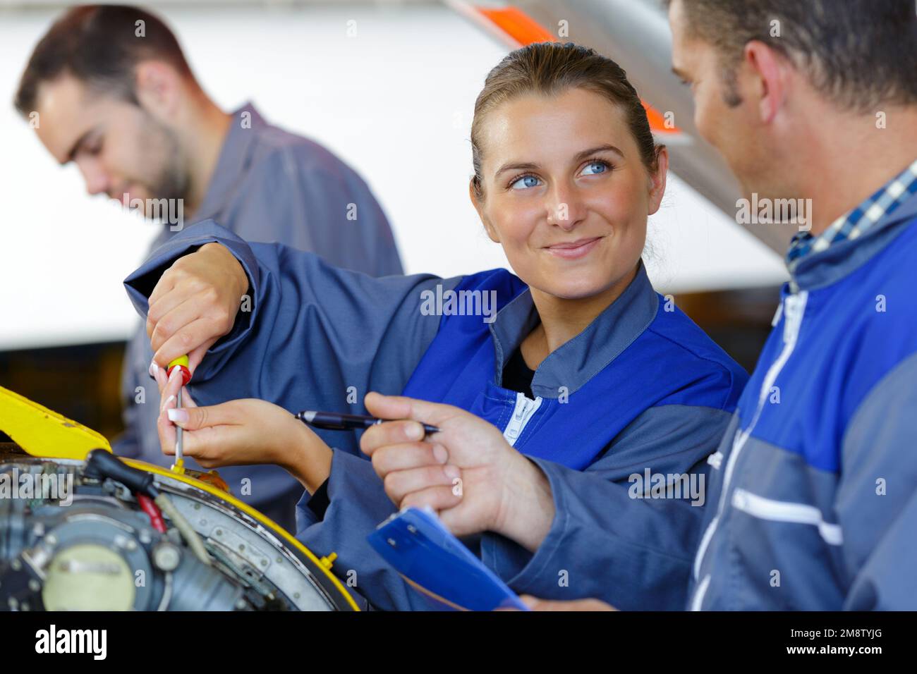 female apprentice mechanic smiling at supervisor Stock Photo - Alamy
