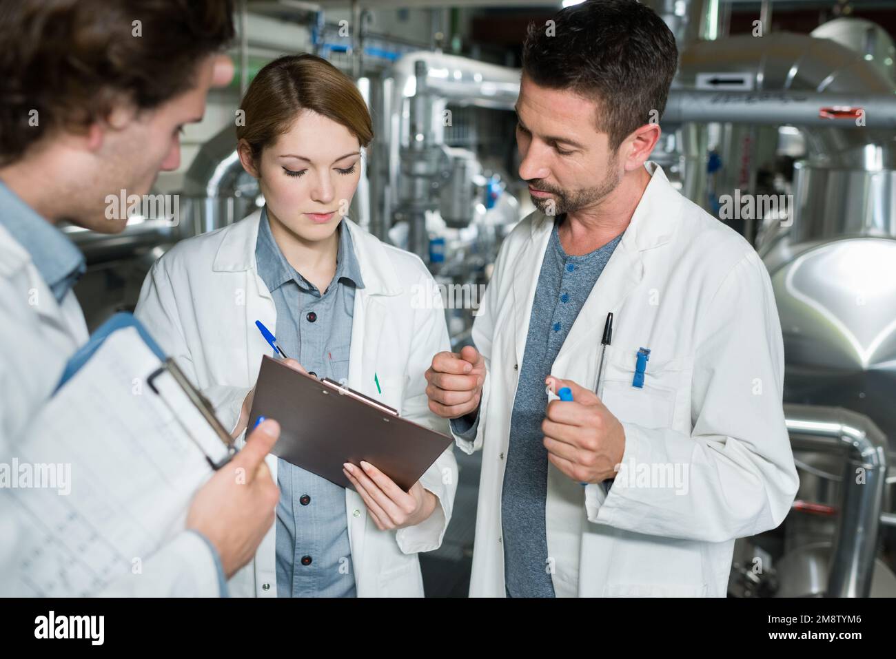 engineers in lab coats working in a factory Stock Photo - Alamy