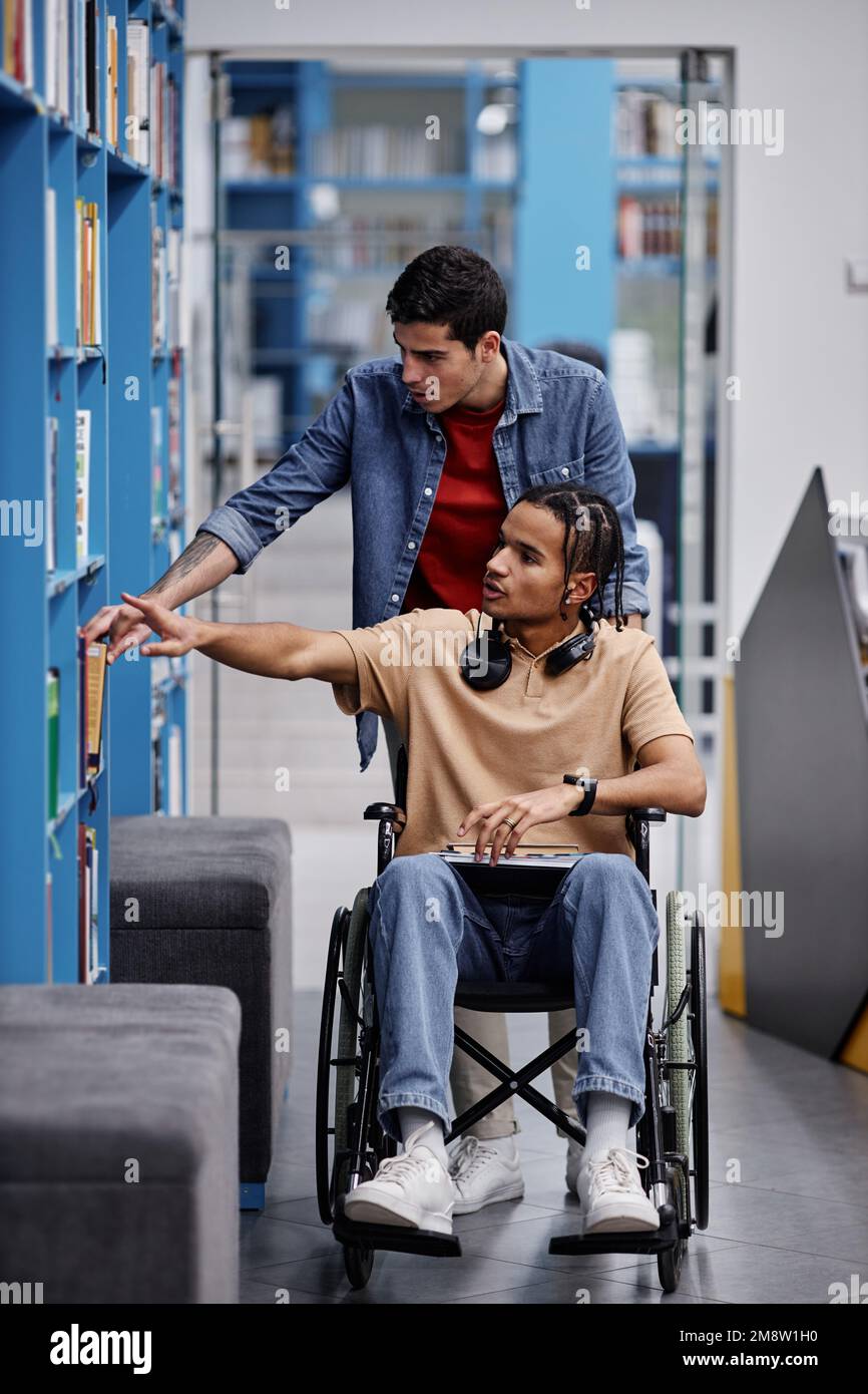 Vertical full length portrait of young man assisting student with ...