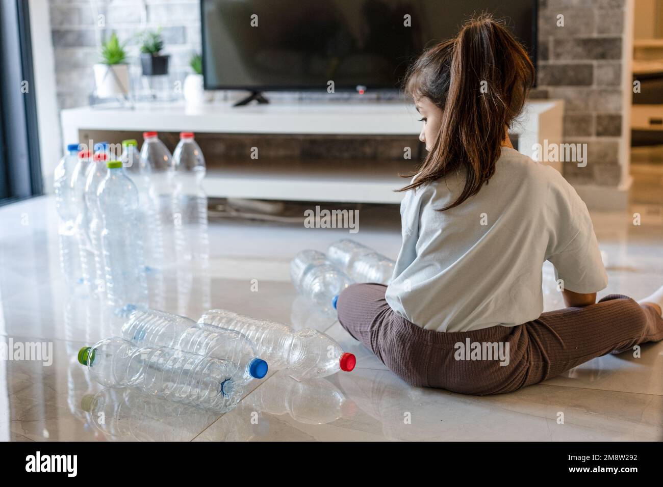 Little girl play with plastic bottle toys Stock Photo - Alamy