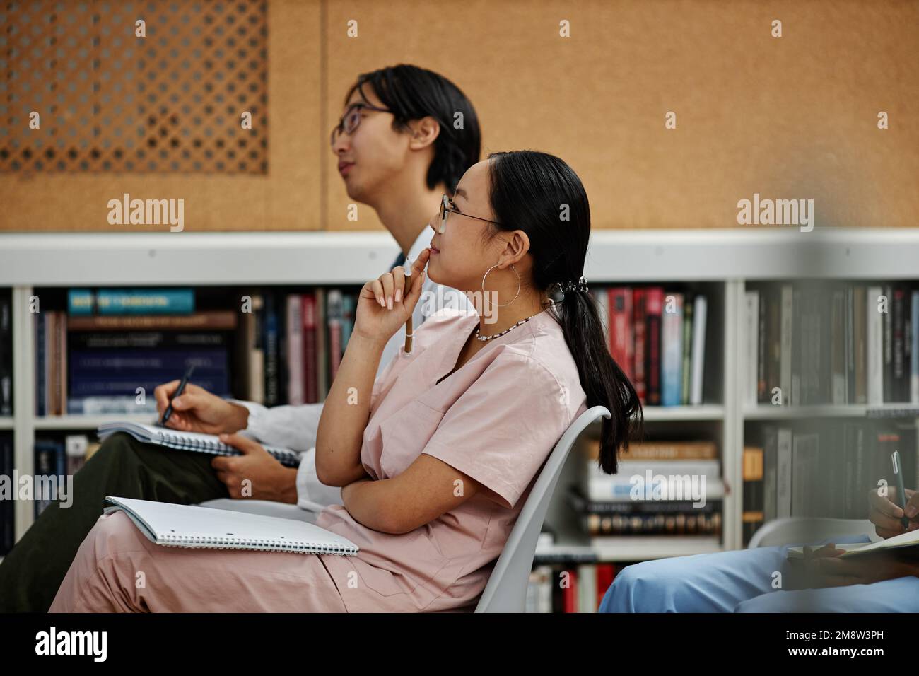 Side view portrait of young med students sitting in row in audience ...