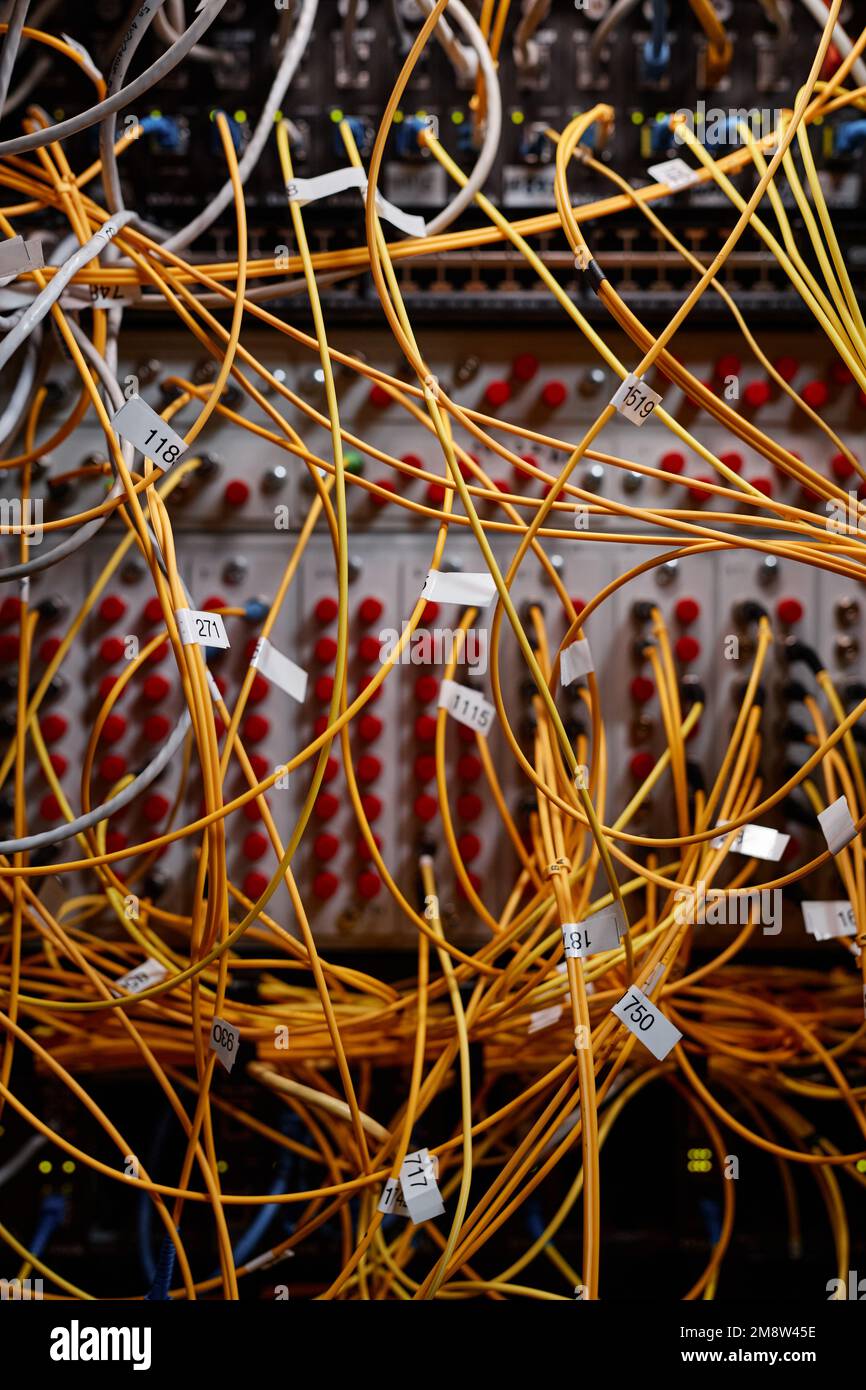 Vertical background image of server cabinet with yellow internet cables ...