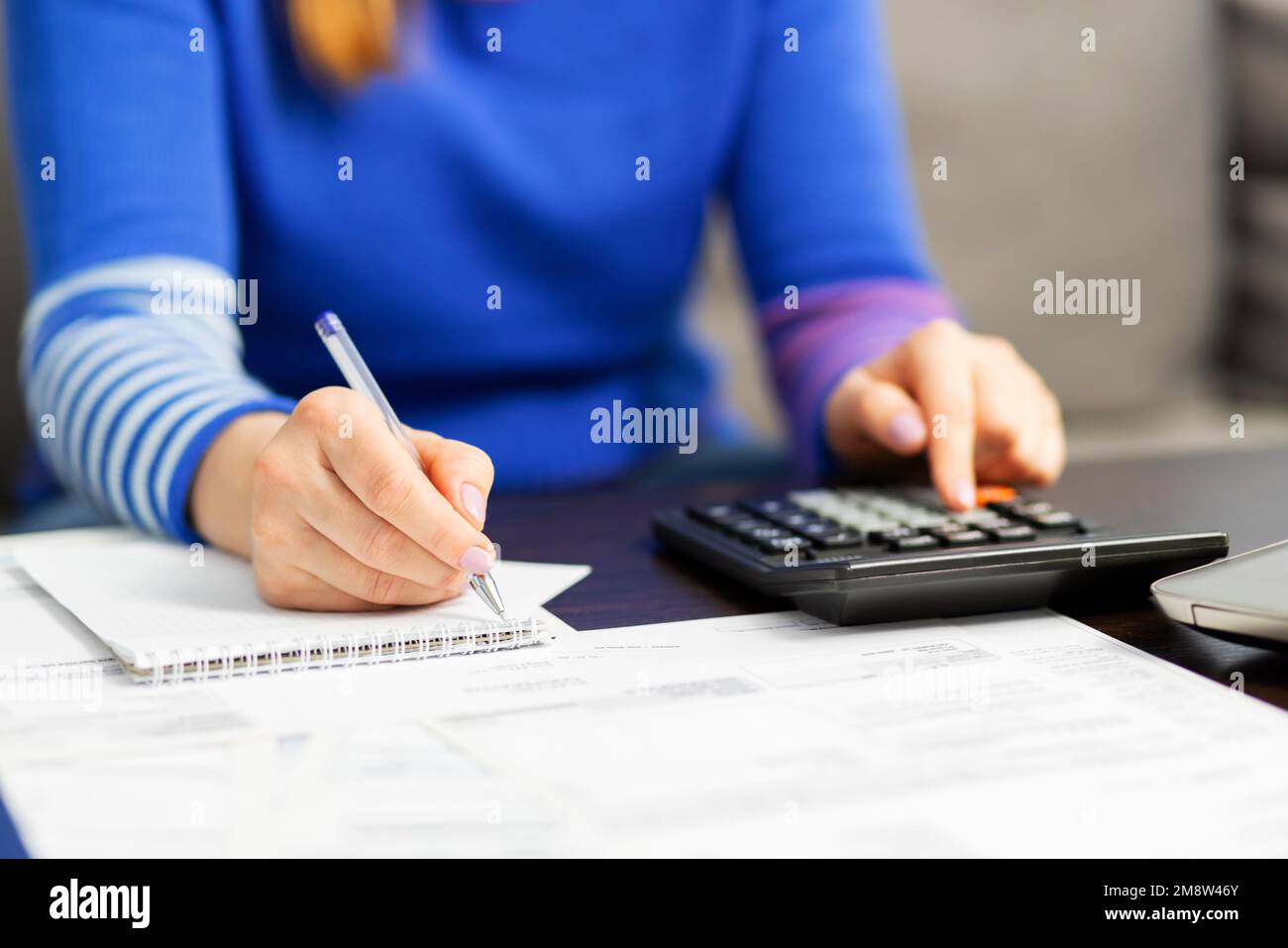 Woman using calculator for calculate domestic bills at home Stock Photo ...