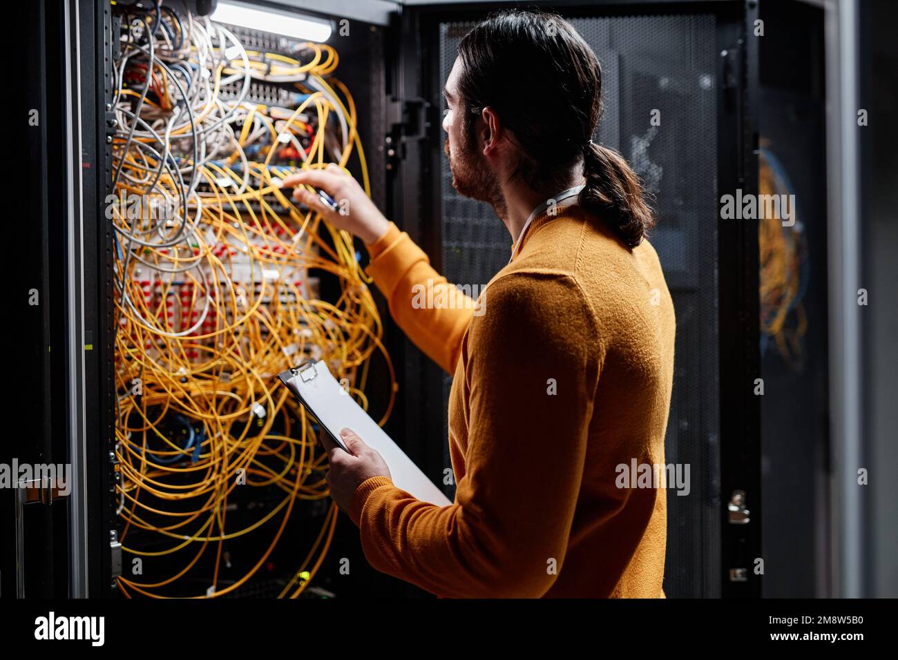 Side view portrait of network technician working with servers and ...