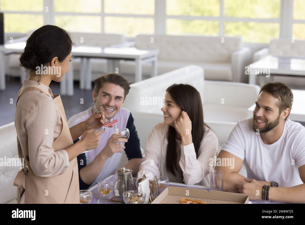 Indian waitress listening to group of happy customers in cafe Stock ...