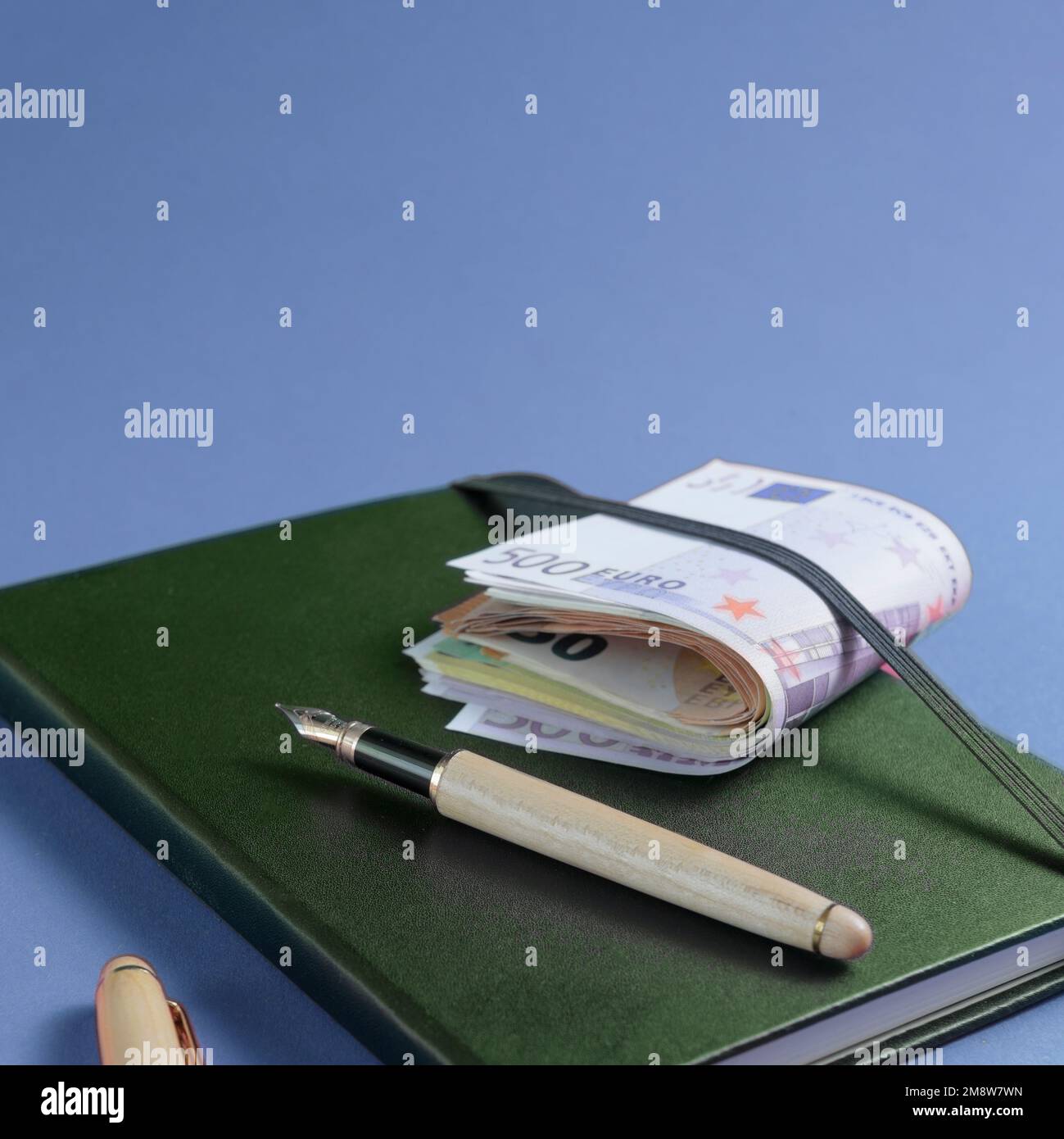 fountain pen. euro banknotes, and accounting black book on blue ...