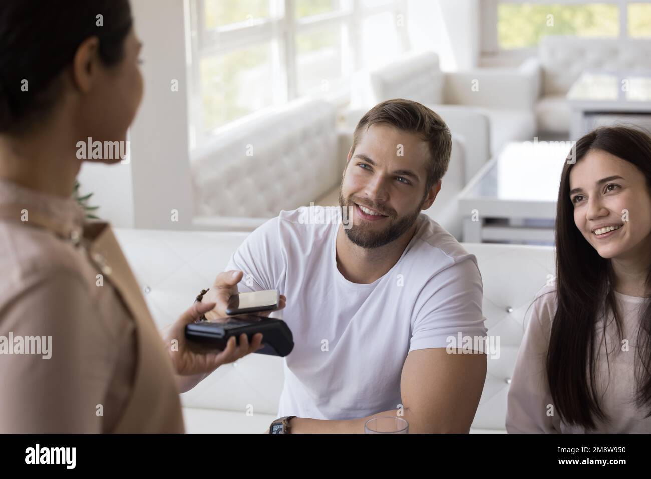 Happy customers paying using contactless hi-res stock photography and ...