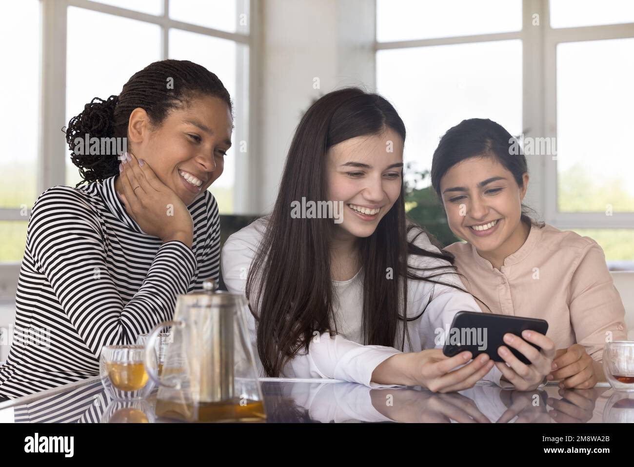 Happy multiethnic female friends talking on video call Stock Photo - Alamy