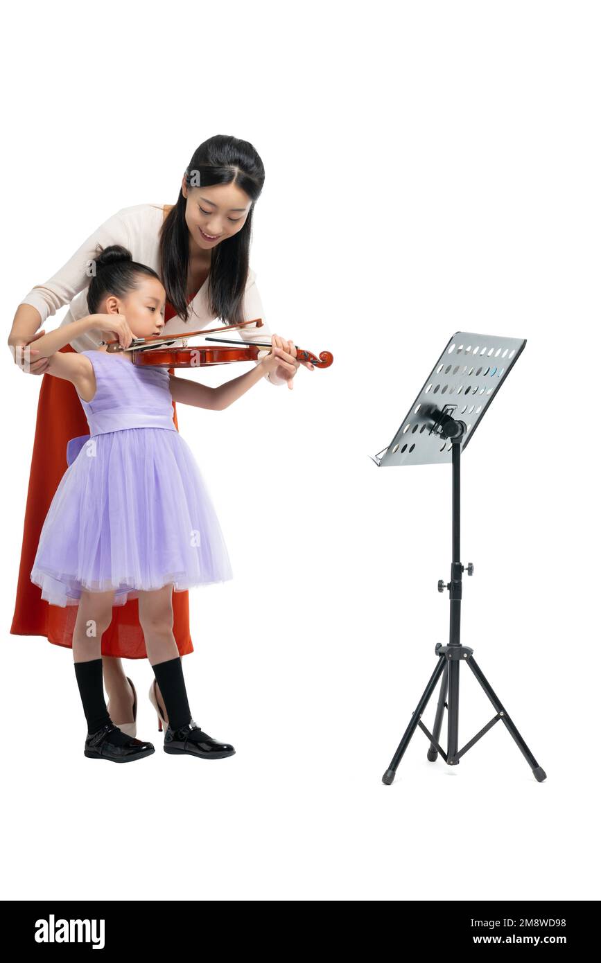 The female teacher guide girl playing Musical Instruments Stock Photo ...
