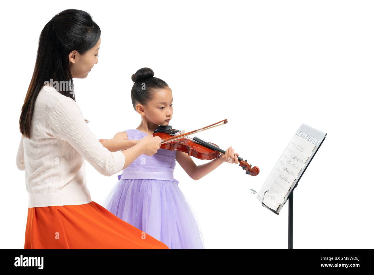 The female teacher guide girl playing Musical Instruments Stock Photo ...
