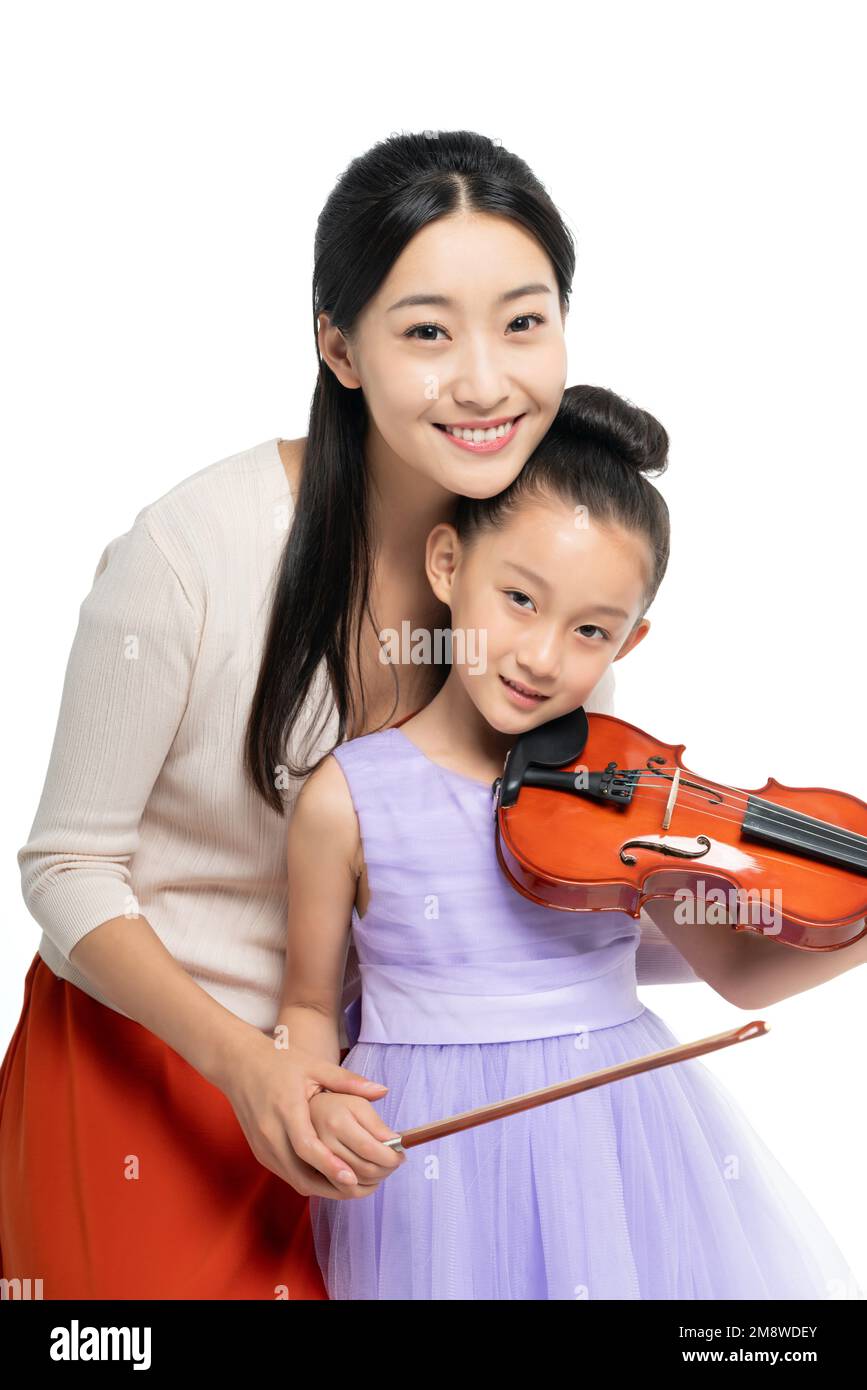 The female teacher guide girl playing Musical Instruments Stock Photo ...