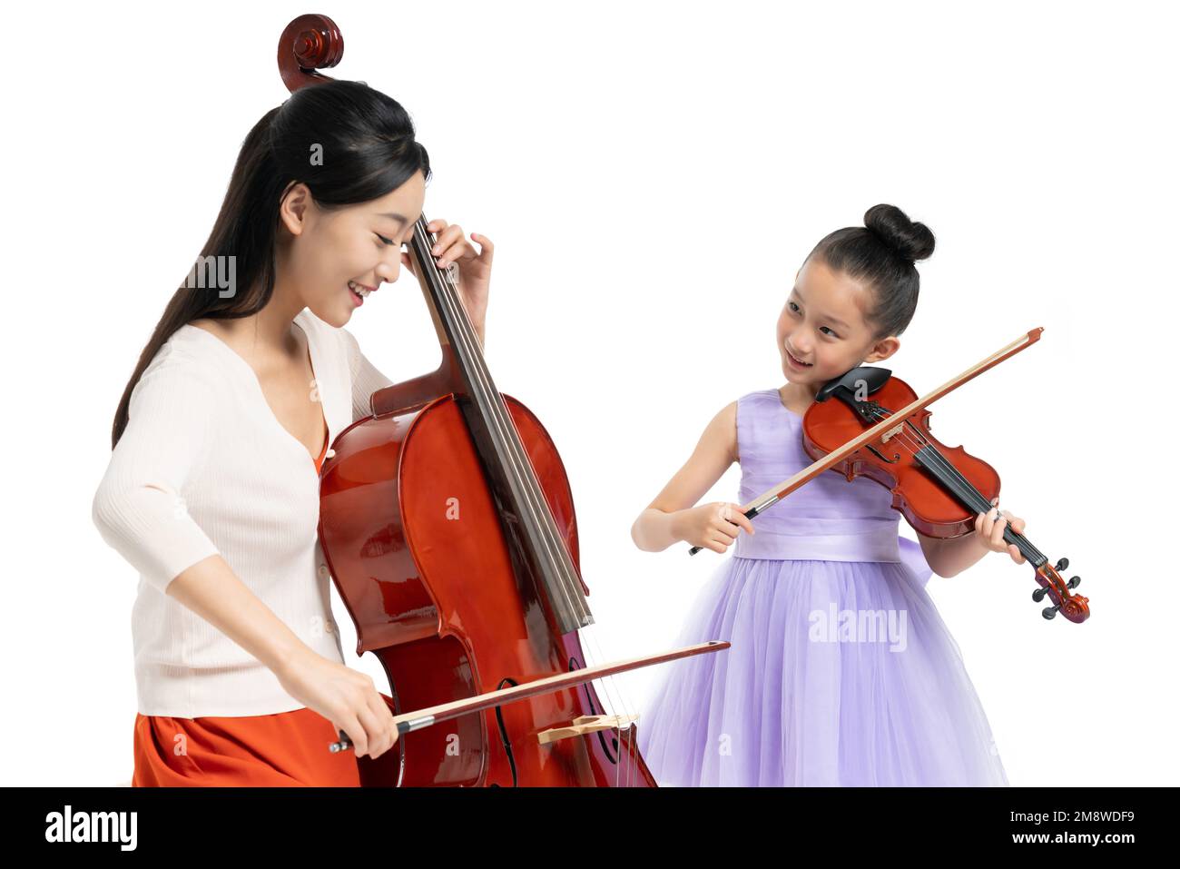 The female teacher guide girl playing Musical Instruments Stock Photo ...