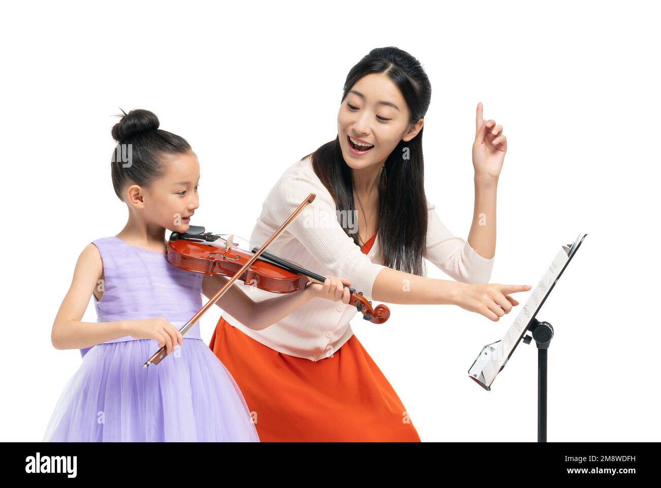 The female teacher guide girl playing Musical Instruments Stock Photo ...
