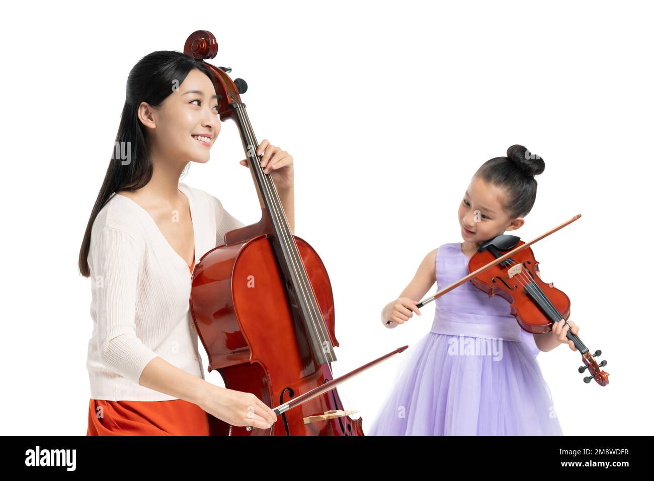 The female teacher guide girl playing Musical Instruments Stock Photo ...