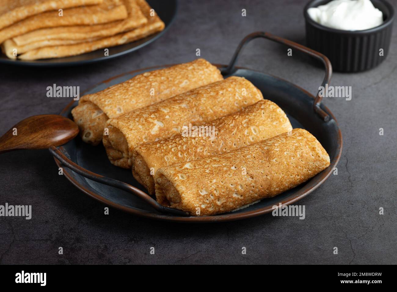 Thin pancakes or crepes stuffed with cottage cheese on grey background ...