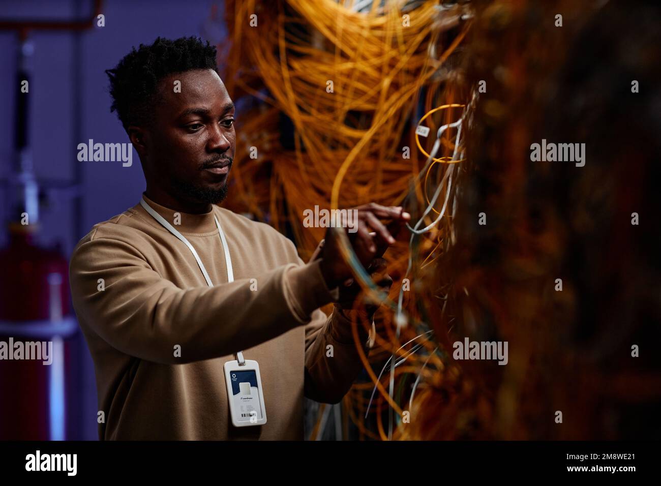Waist up portrait of black young man as system administrator setting up ...