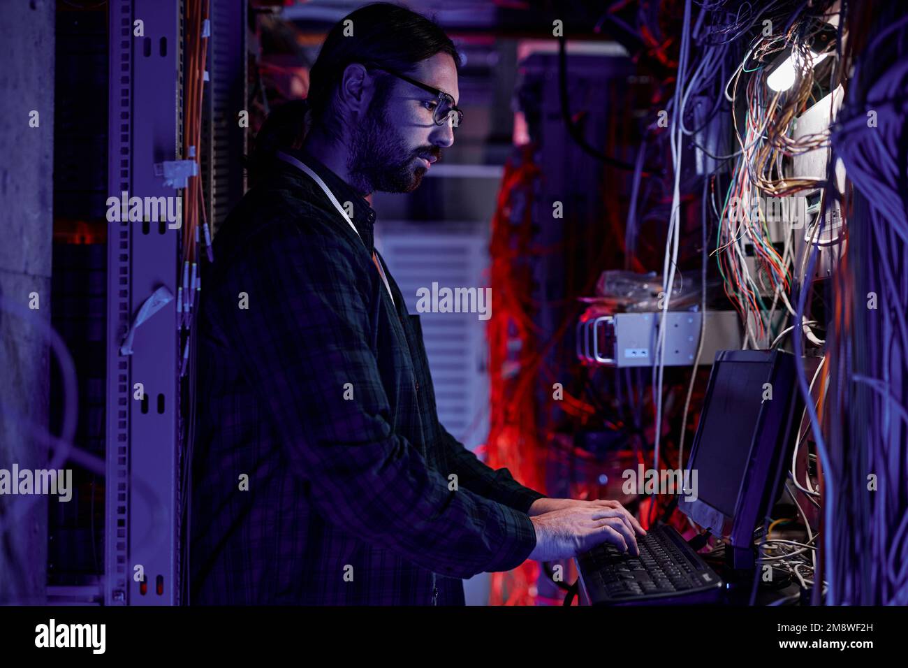 Side view portrait of bearded system administrator setting up server ...