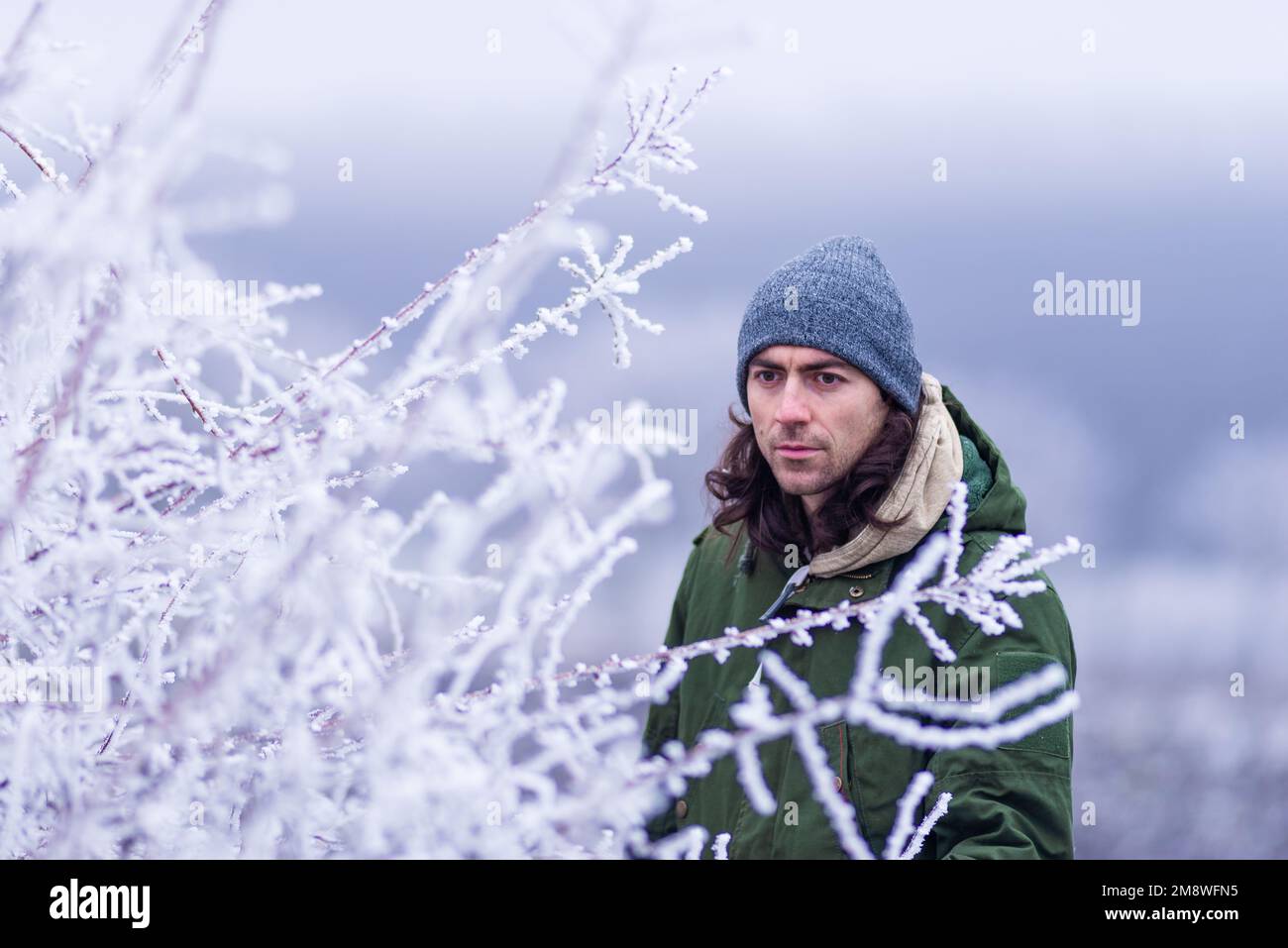 close up frost man male young 30 years old long hair snow a winter day ...