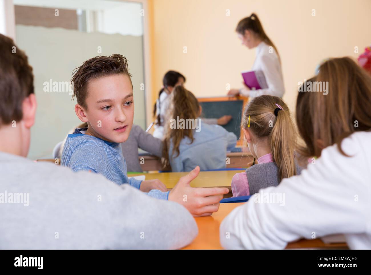 Pupils chattering at lesson Stock Photo - Alamy
