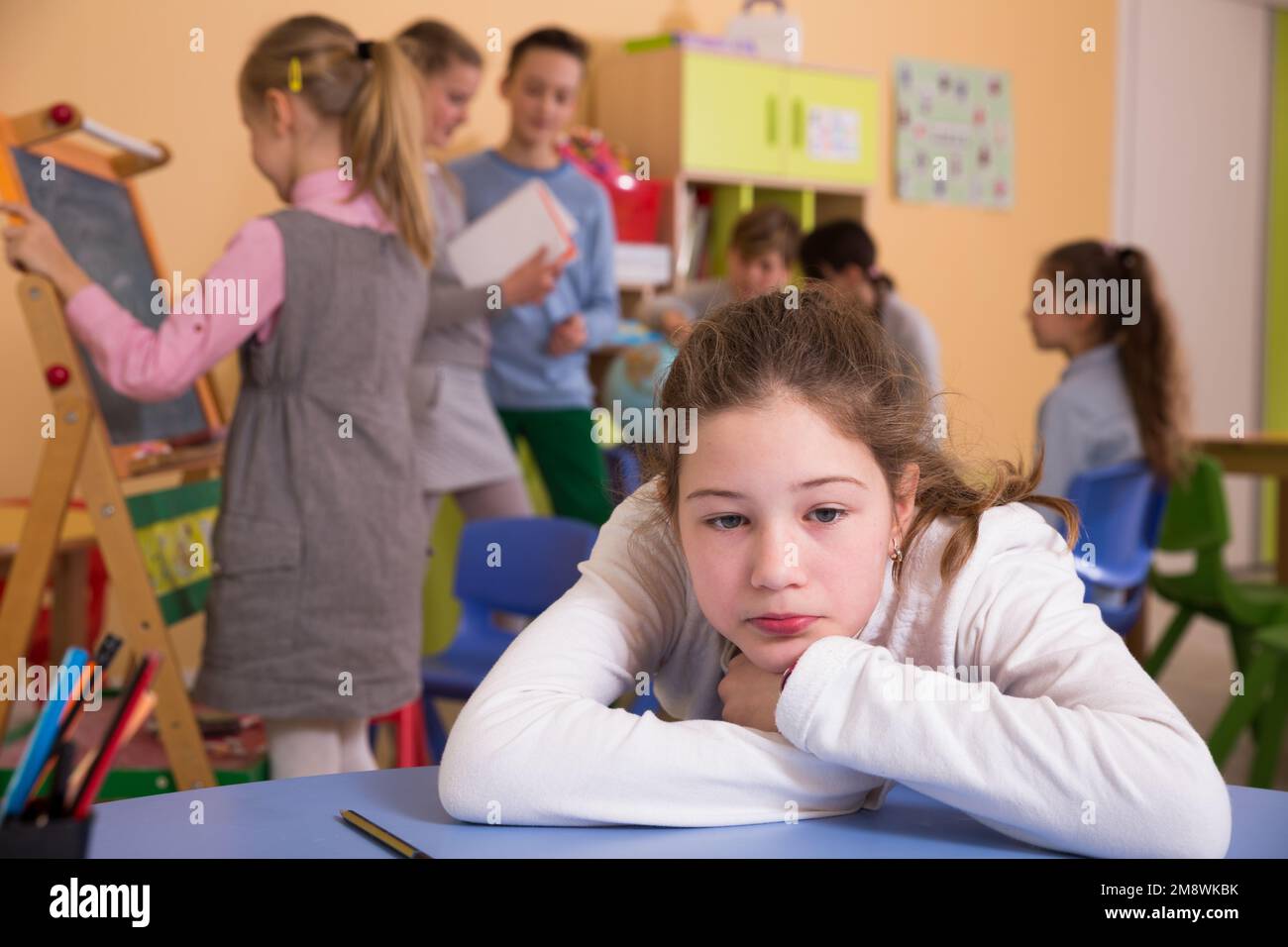 Upset girl in schoolroom during break Stock Photo - Alamy