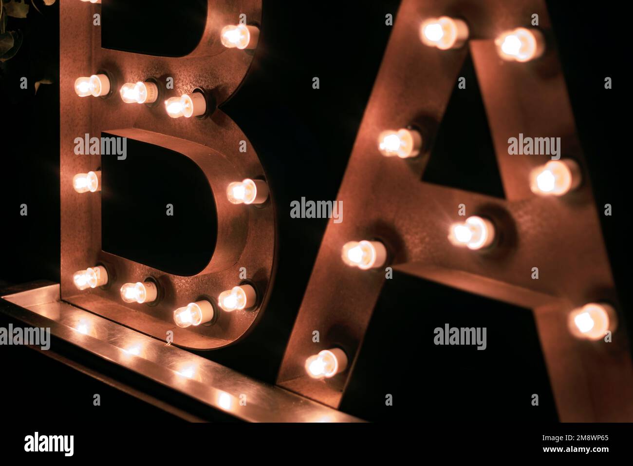 B A R letters lighted by spotlights on a dark black background Stock ...