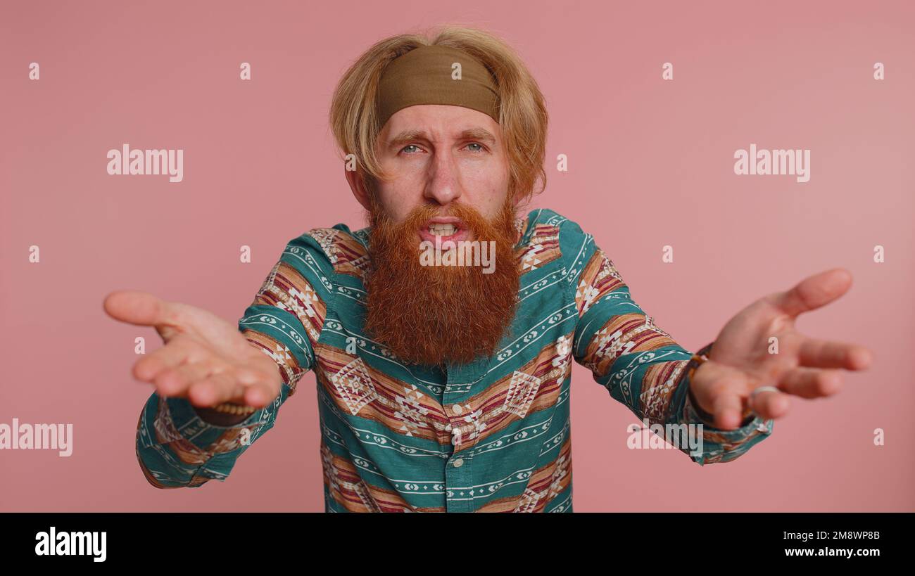 What Why. Sincere irritated redhead hippie man raising hands in ...