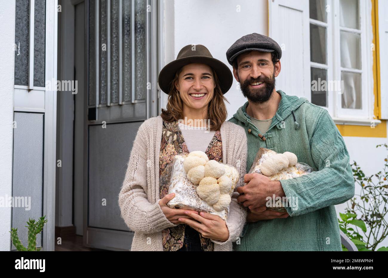 Cute farmer couple holding blocks of lion mane mushrooms Stock Photo ...