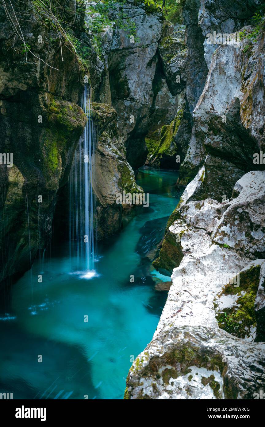 A natural view of the Soca River and waterfall in a forest in Slovenia ...