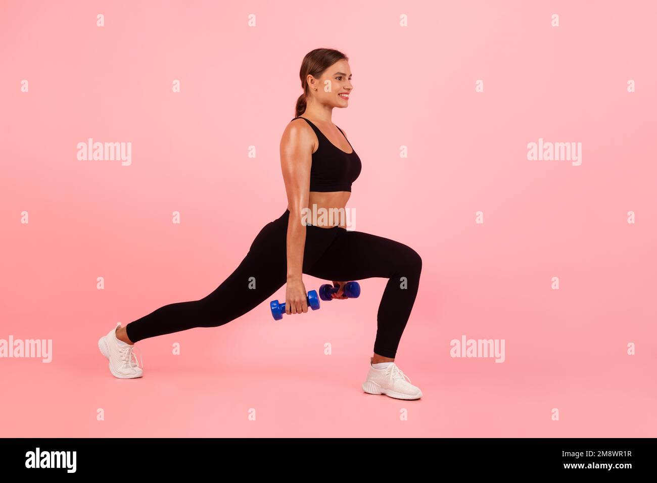 Sporty Young Woman Holding Dumbbells And Making Deep Lunges Exercise In ...
