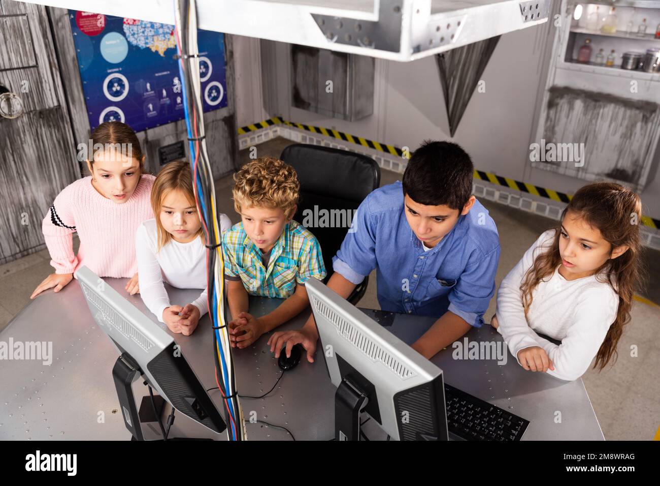 Tweenagers using computer to solve conundrum in lost room bunker Stock ...