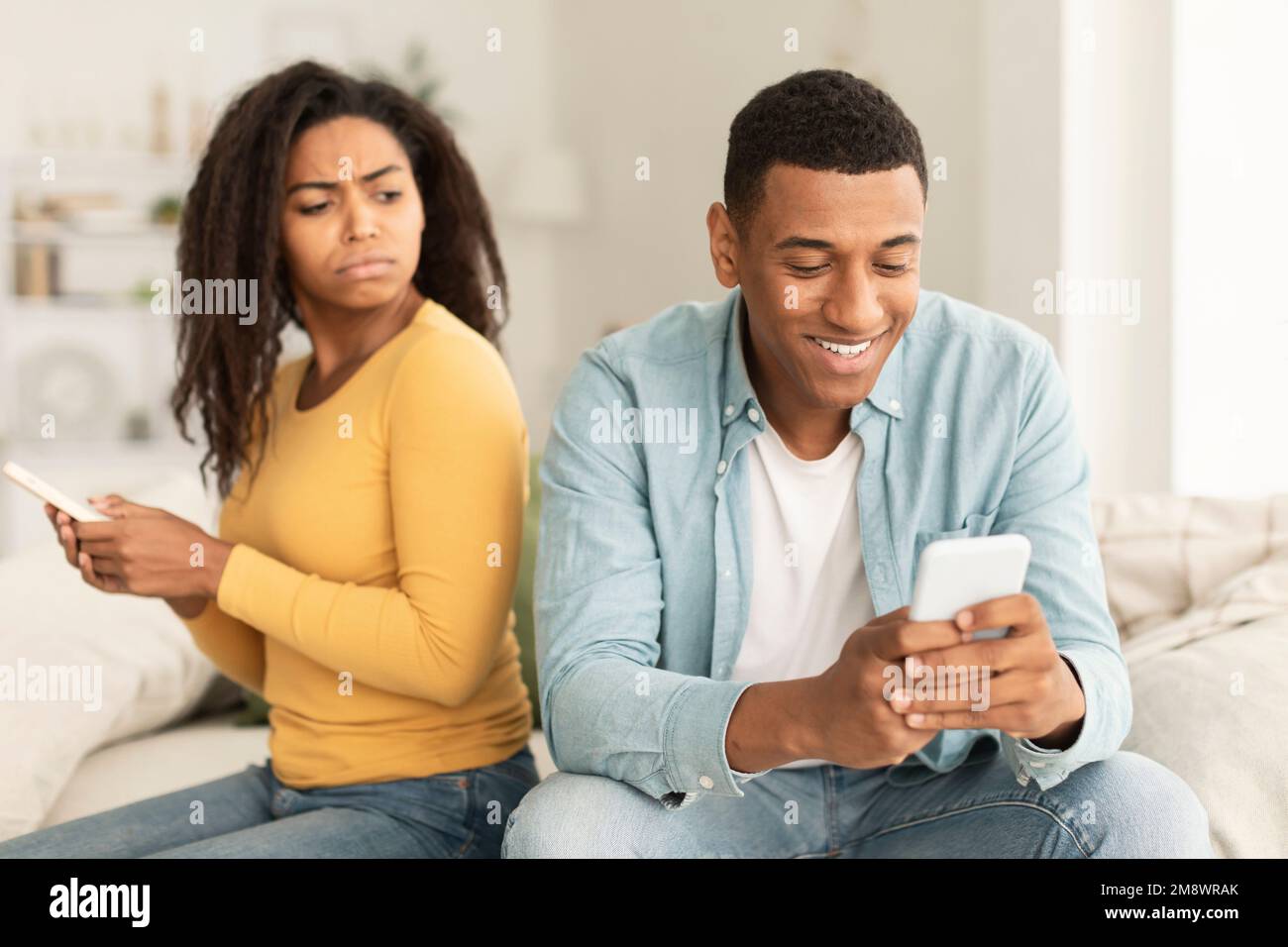 Jealous man looks woman phone hi-res stock photography and images - Alamy