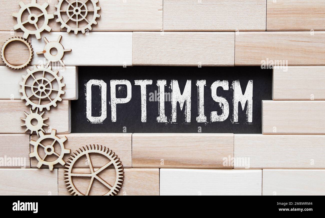 word Optimism on wooden block Stock Photo - Alamy