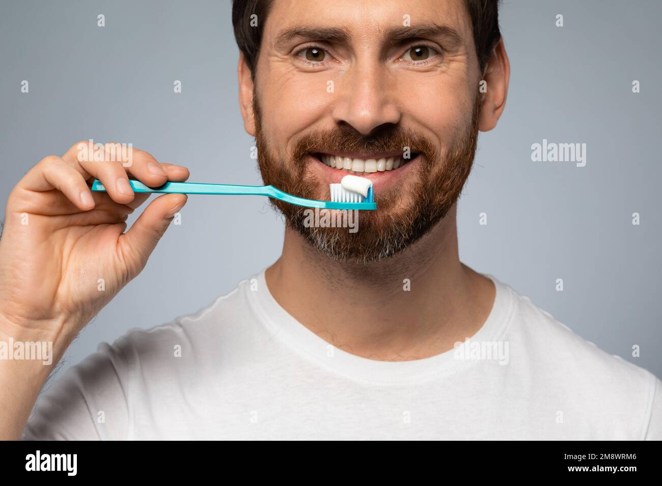 Happy caucasian man cleaning teeth with toothbrush and smiling ...