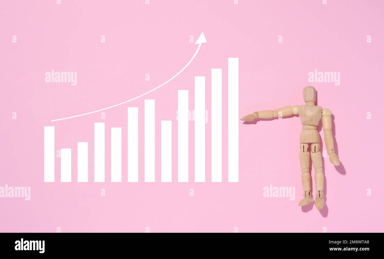 Wooden mannequin and graph with growing indicators, high income. Pink ...