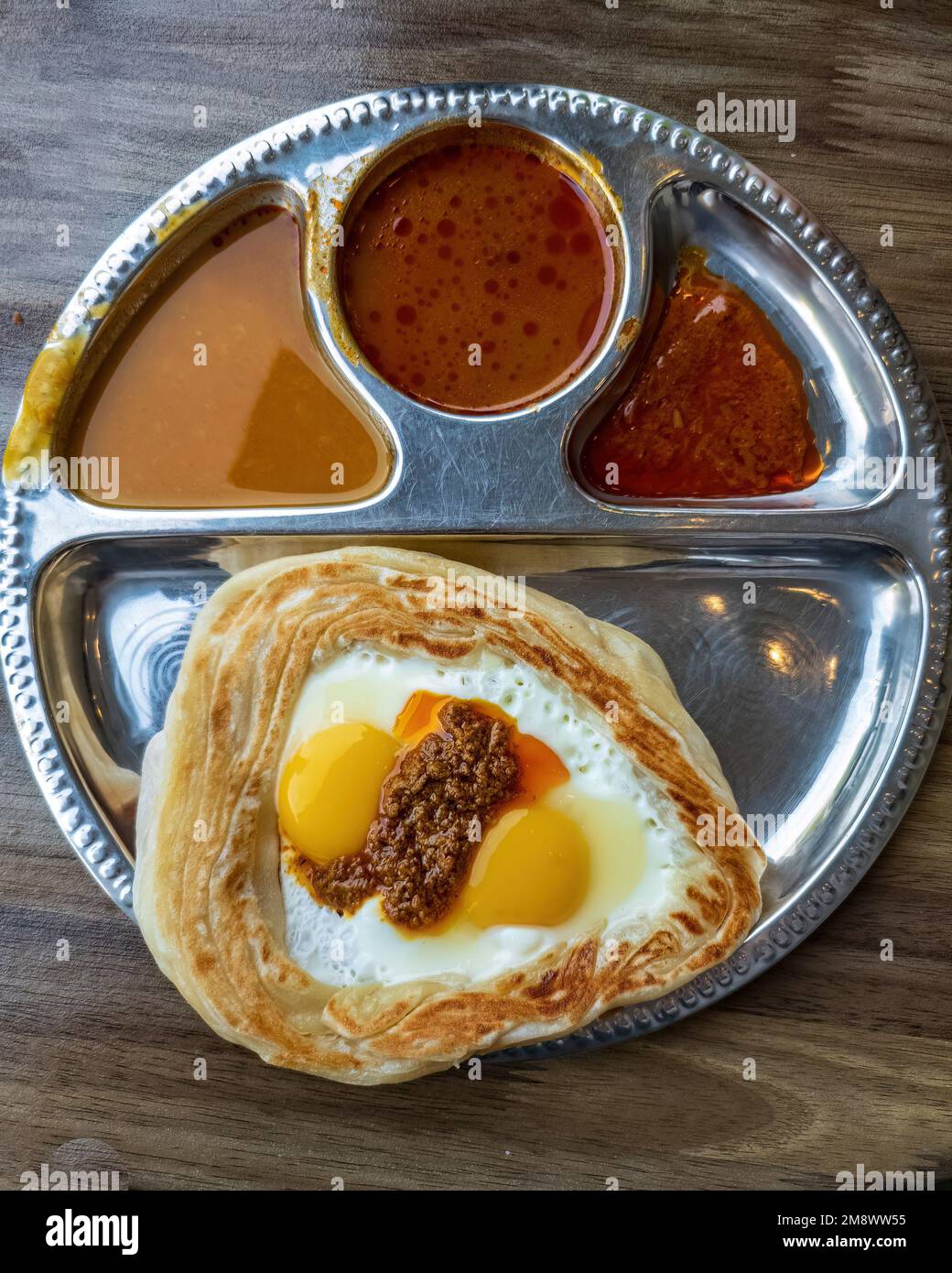 A Roti Sarang Burung served with different gravies, pratha with half ...