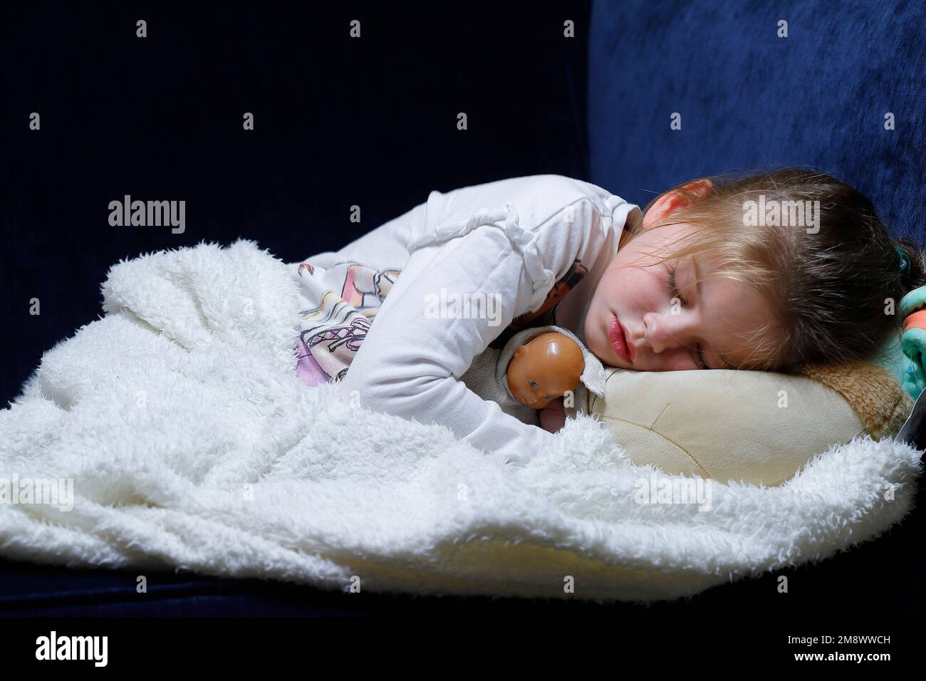 A 7 year old girl fast asleep on the sofa with her comforter blanket ...