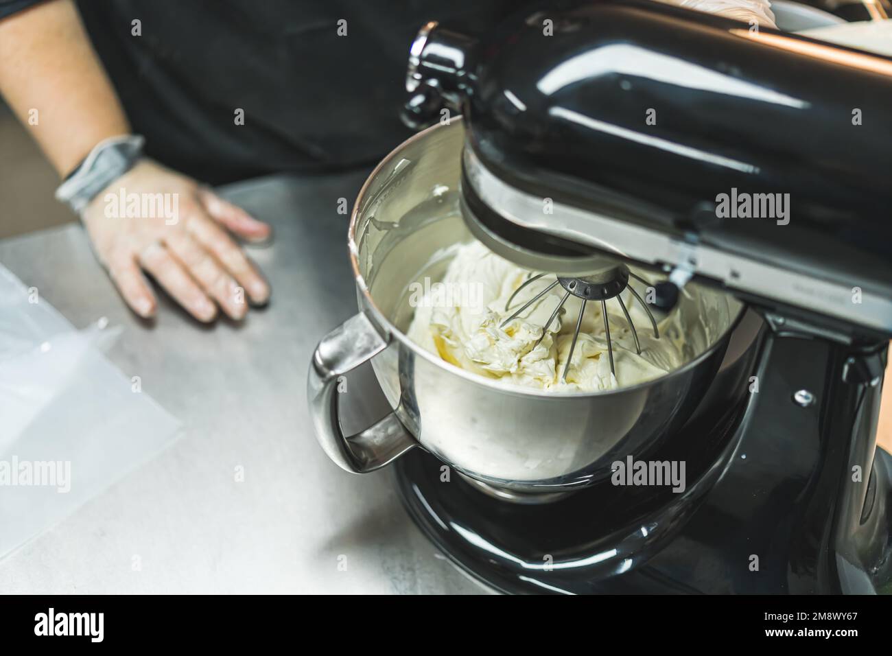 Professional unrecognisable baker making buttercream frosting using ...