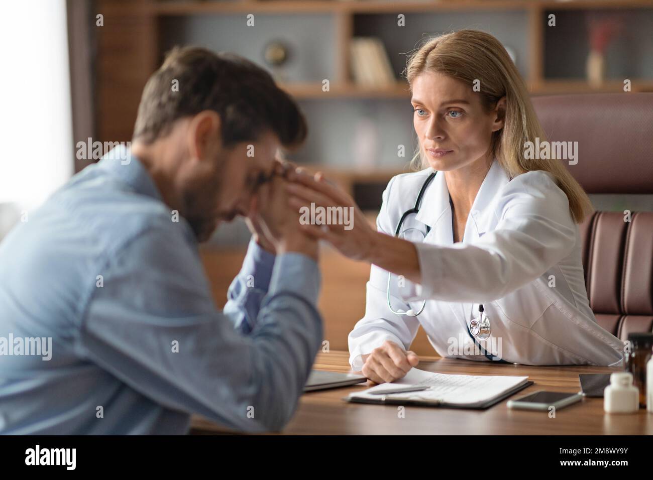 Doctor Woman Comforting Upset Male Patient During Meeting In Clinic ...