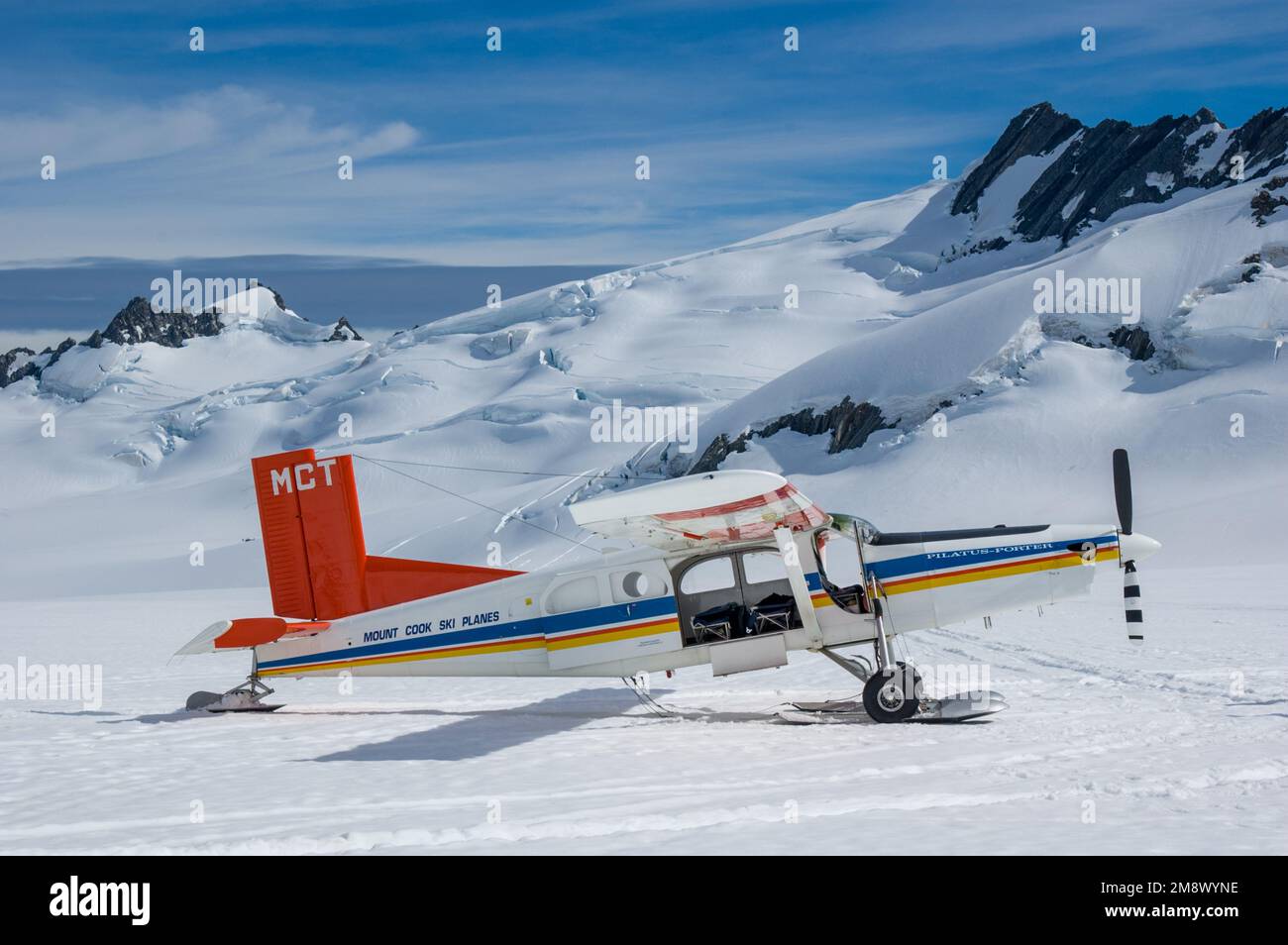 Tourist flight with a ski plane landing on the glacier snow at high ...