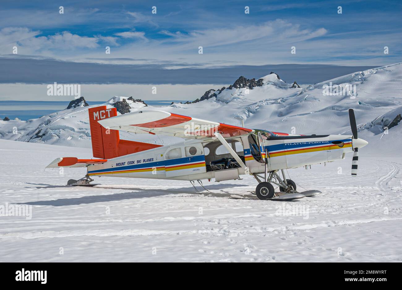 Tourist flight with a ski plane landing on the glacier snow at high ...