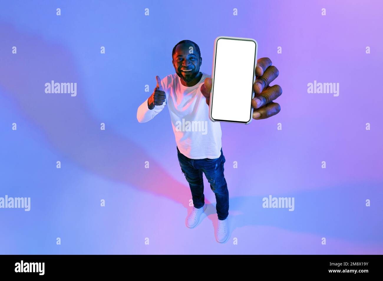 Cheerful black man showing big cell phone, mockup Stock Photo - Alamy