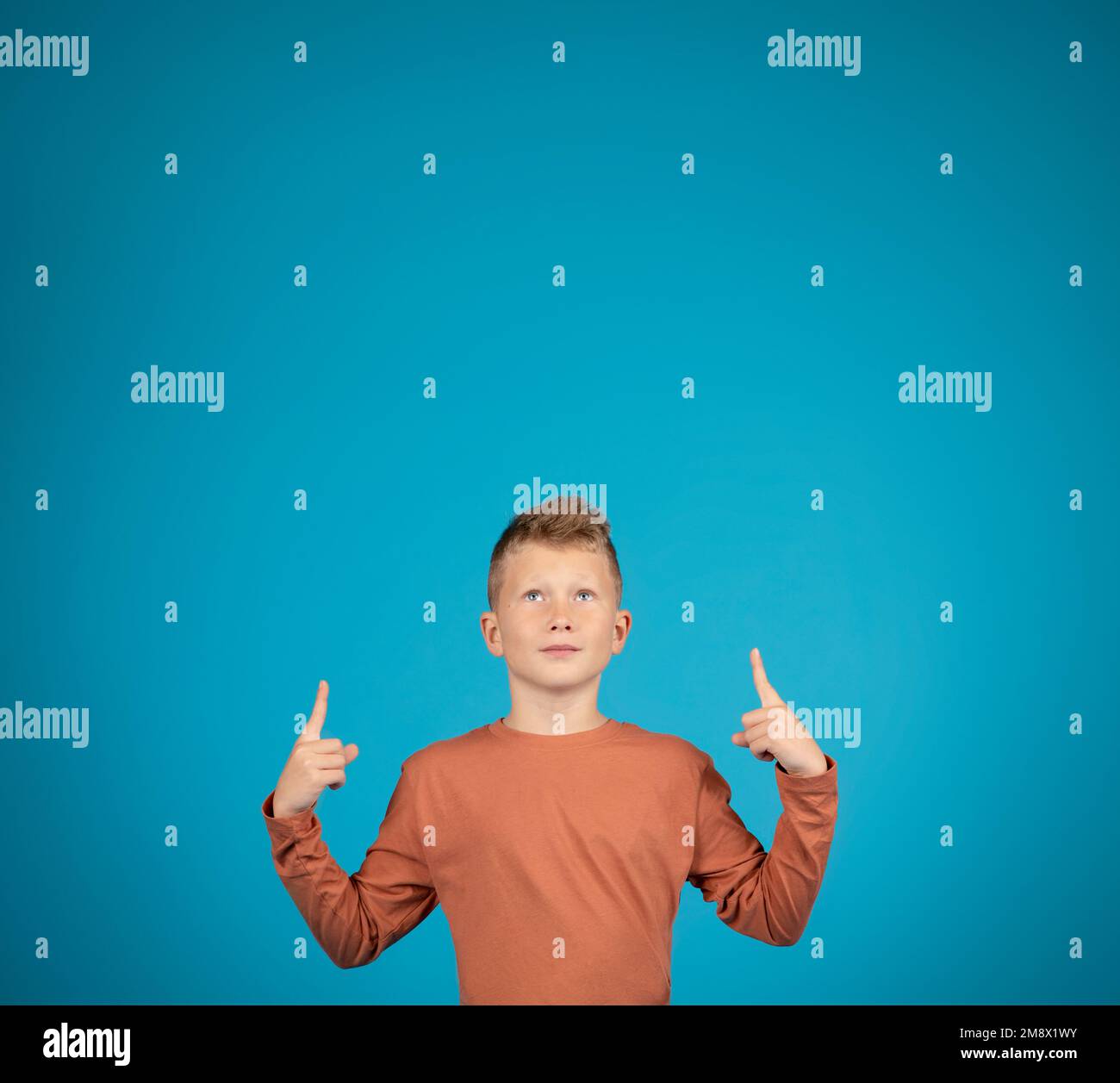 Check This. Cute Preteen Boy Pointing Up At Copy Space Stock Photo - Alamy