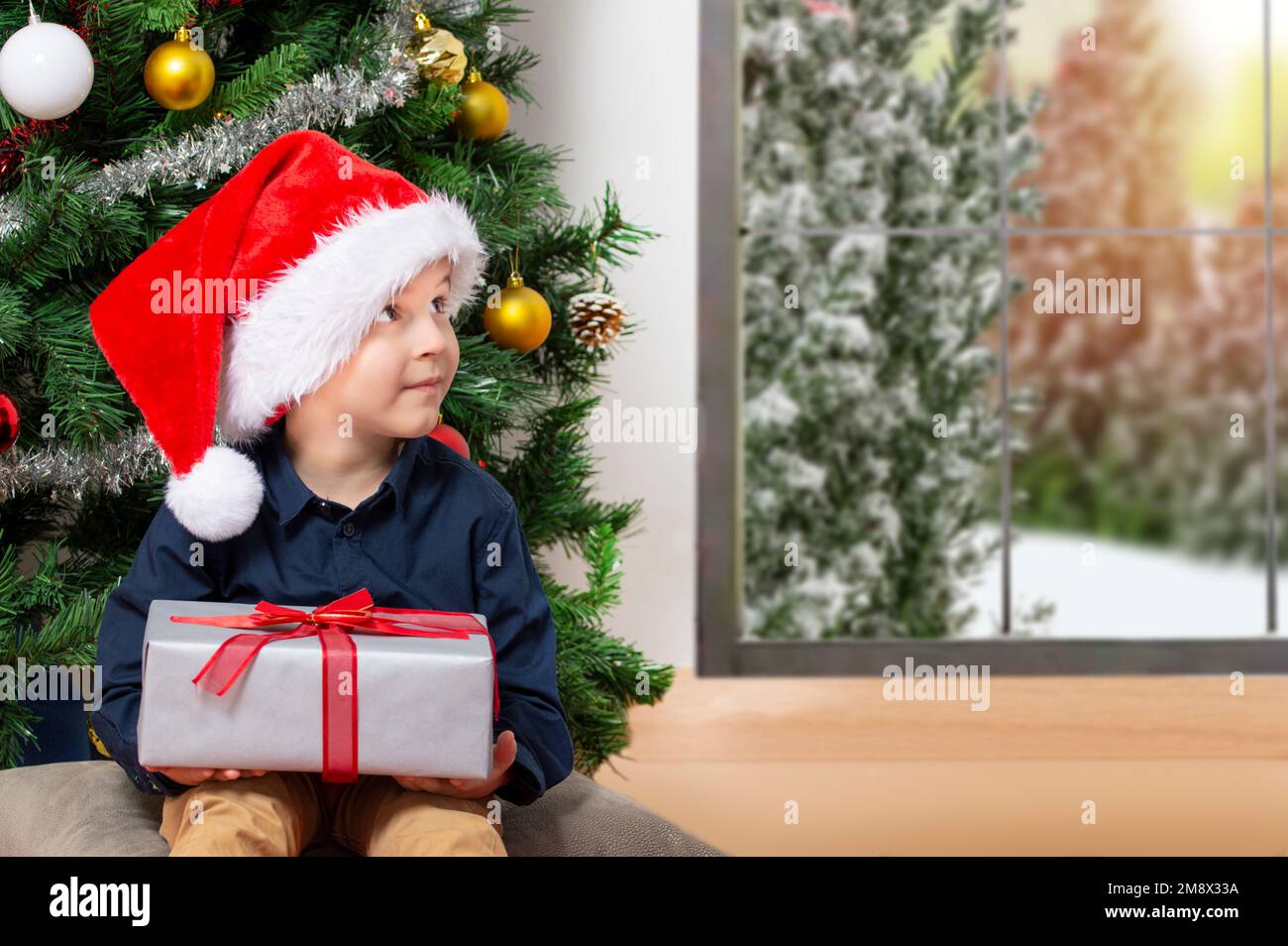 Child in santa hat smiling looking into a window and looking away ...