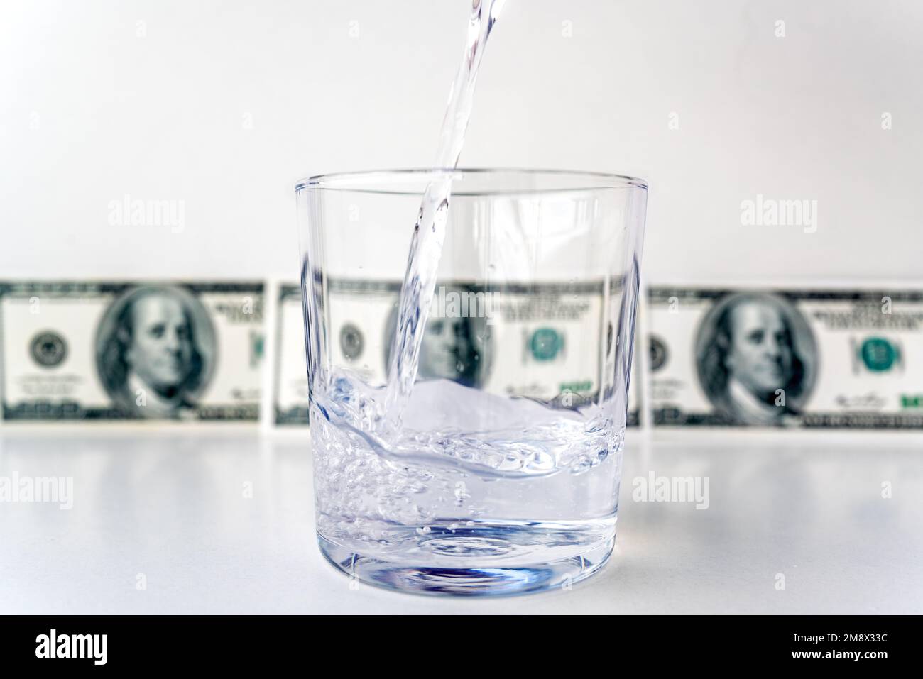 Water splash from glass with dollar bills background in concept of ...