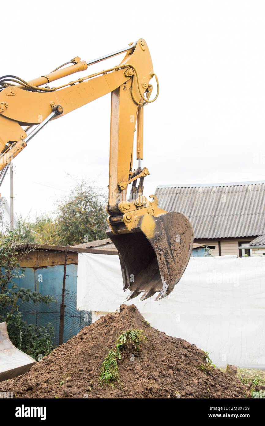 Excavation industrial work. A bulldozer pours out a bucket of land on a ...