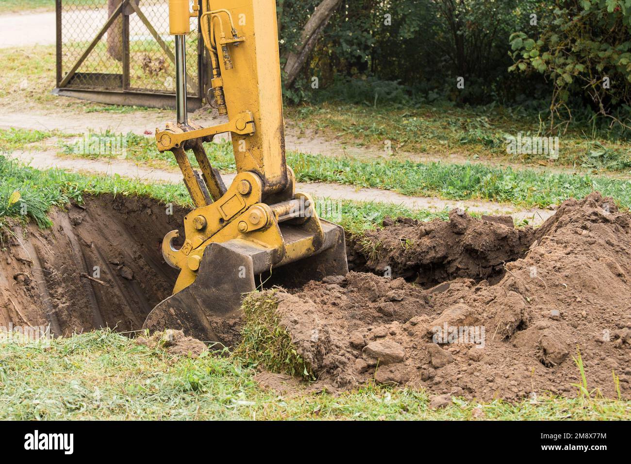 Excavation. A bucket of bulldozer digs and scoops the ground from a ...