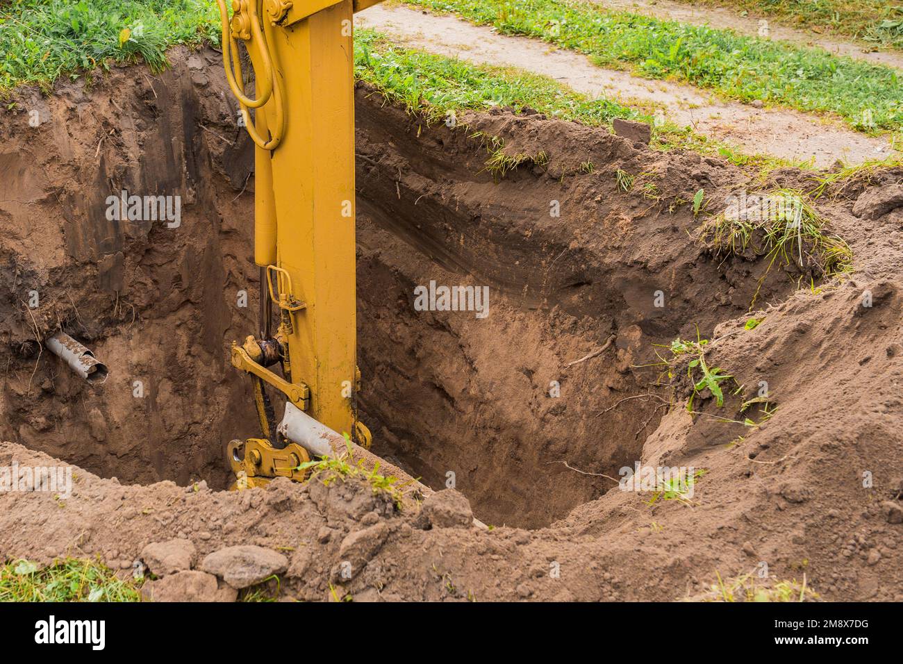 Hydraulic excavator piston digs deep pit in industrial area on ...