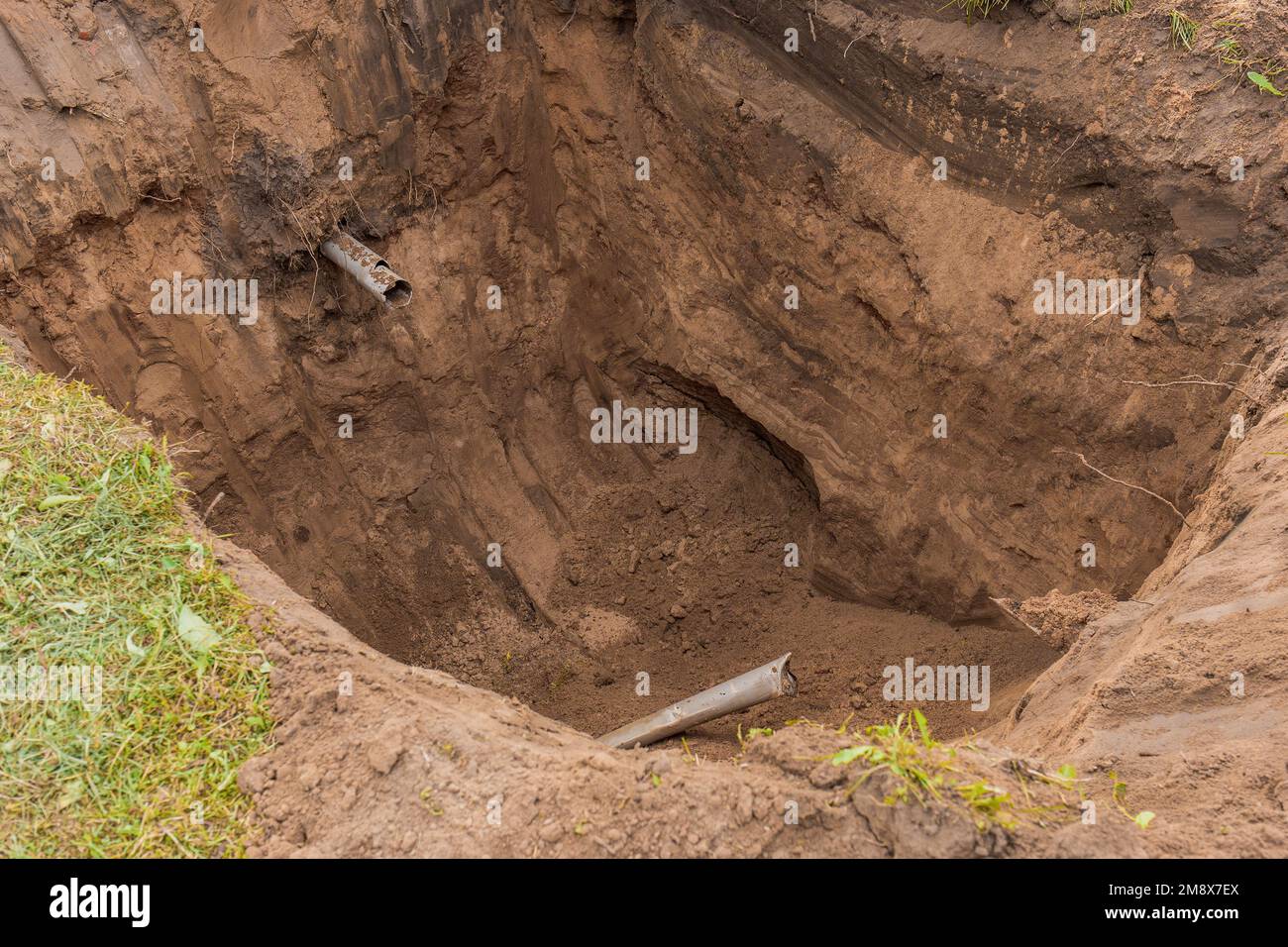 Large deep pit in the ground after digging an excavator sewer pipe in ... Large deep pit in the ground after digging an excavator sewer pipe in ...