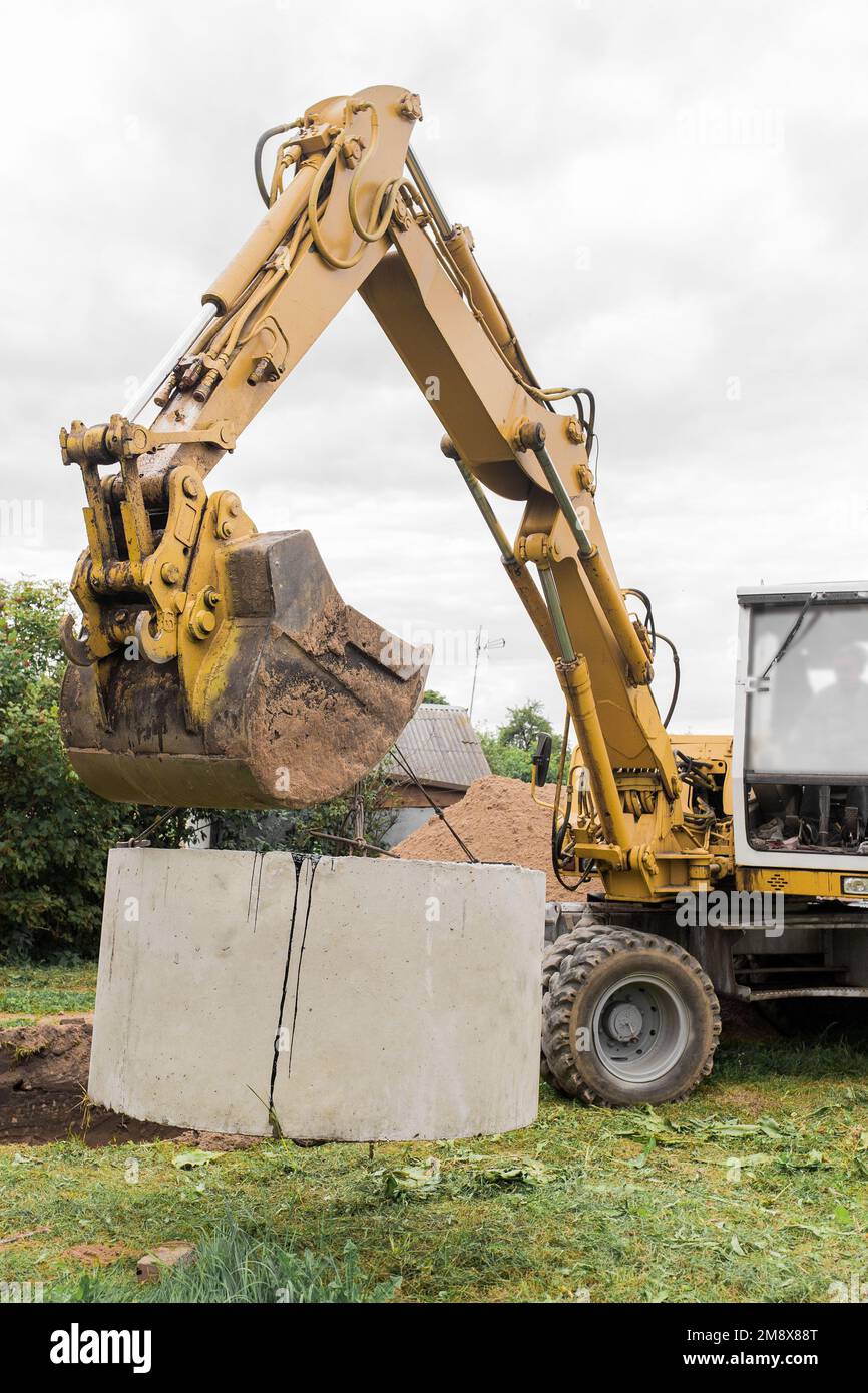 Hydraulic piston system of the excavator with a bucket, lowering into ...